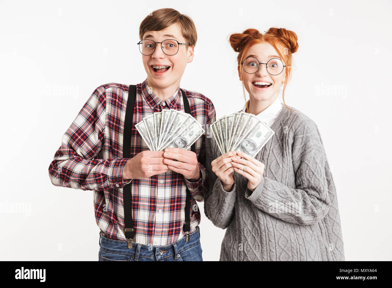 Excited couple of school nerds holding bunch of money banknotes ...