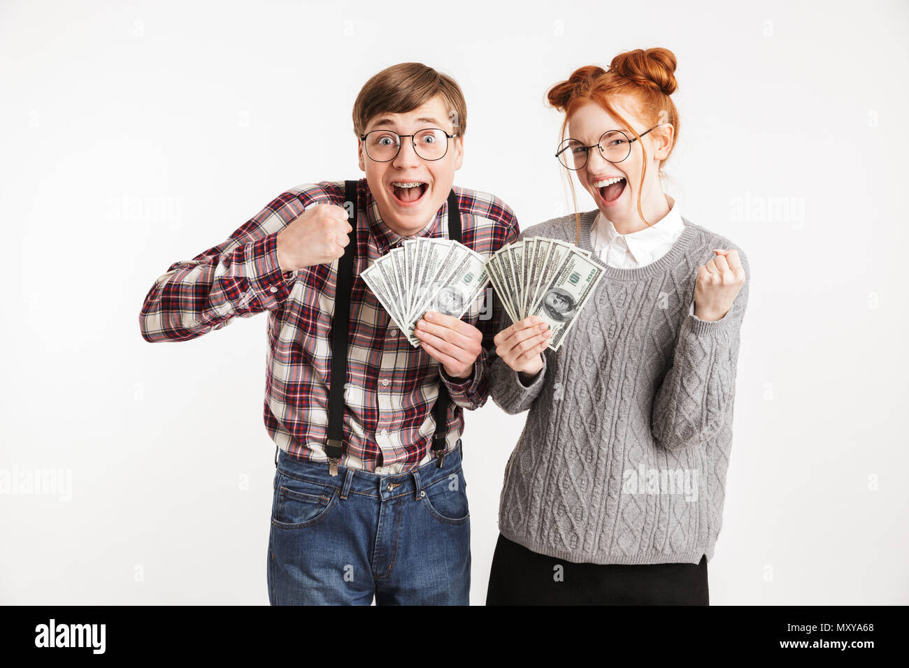 Excited couple of school nerds holding bunch of money banknotes and ...