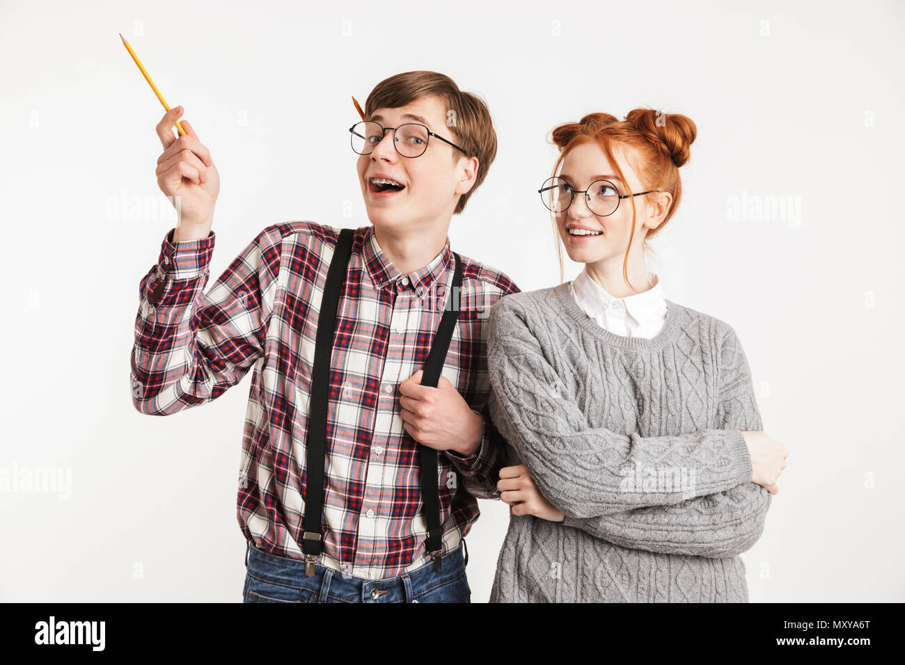 Happy couple of school nerds pointing pencil isolated over white ...