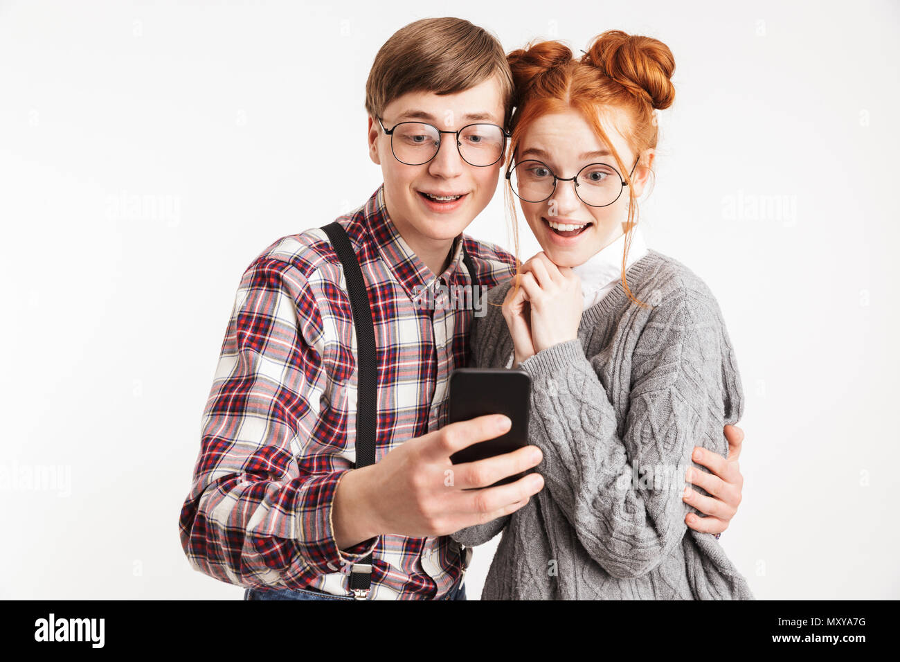 Cheerful couple of school nerds taking selfie with mobile phone ...