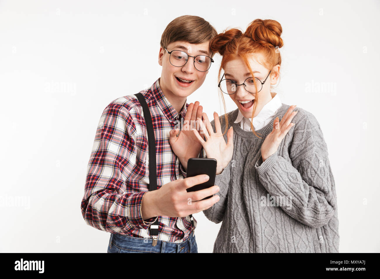 Cheerful couple of school nerds taking selfie with mobile phone ...