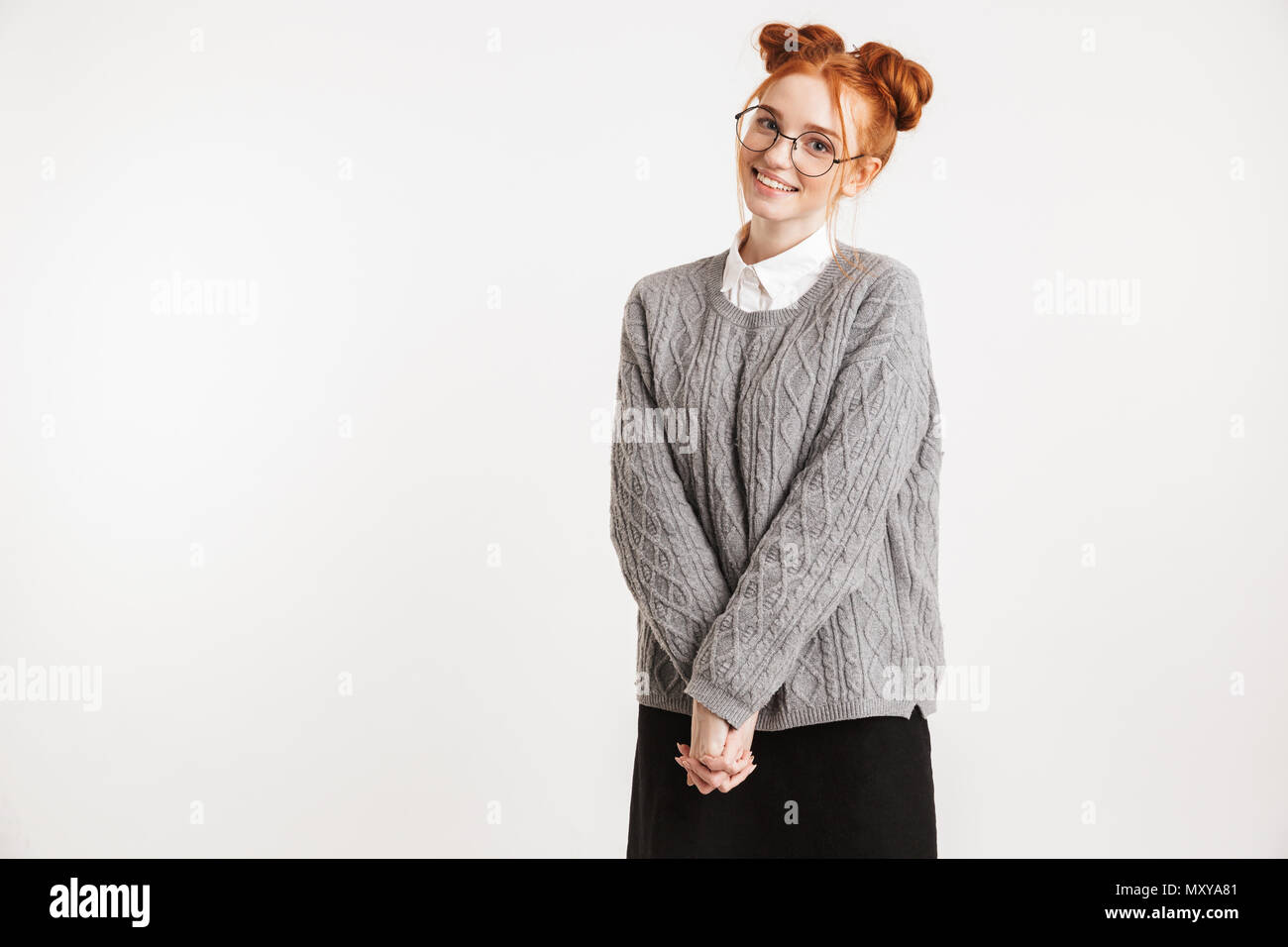 Portrait of a smiling young school nerd girl looking at camera isolated ...