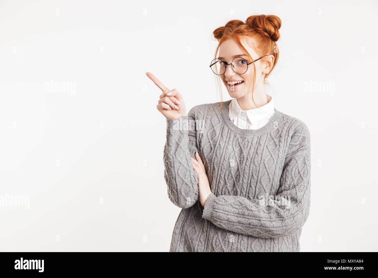Portrait of a cheerful young school nerd girl pointing finger away at ...