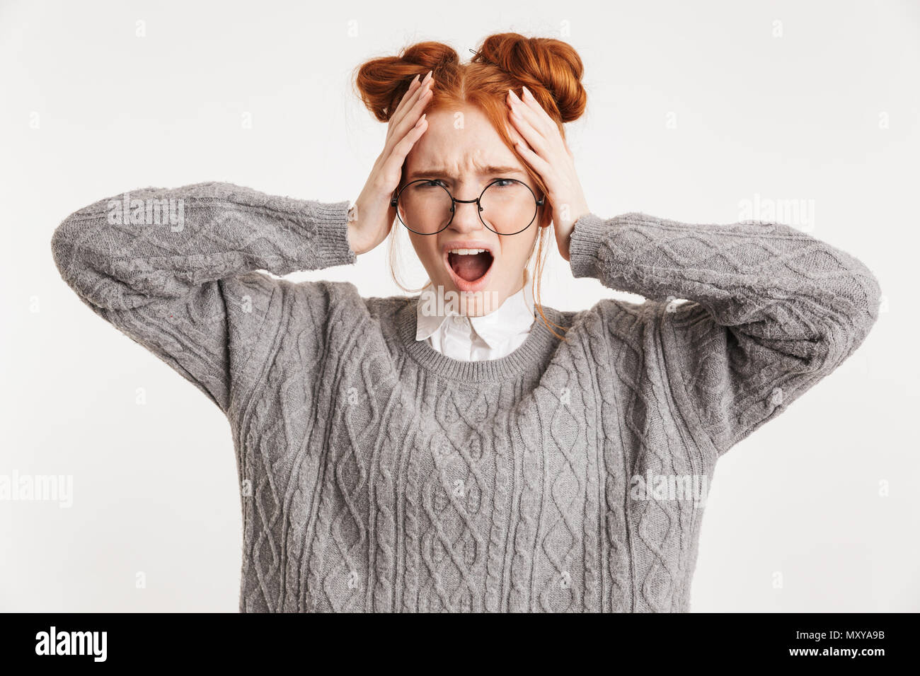 Portrait of an angry young school nerd girl looking at camera isolated ...