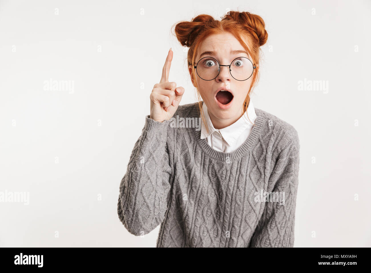 Portrait of an excited young school nerd girl pointing finger up ...