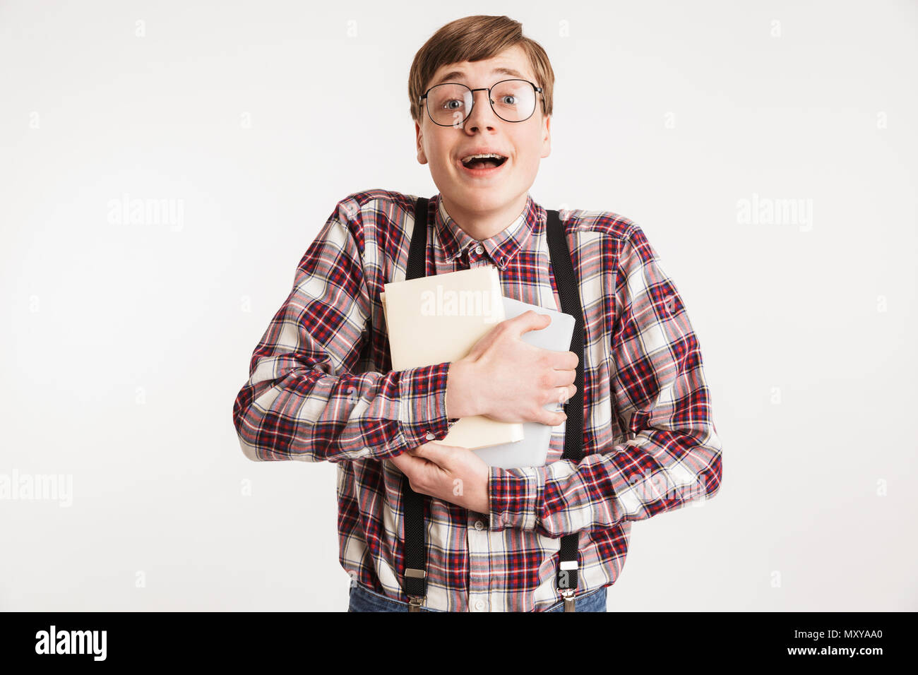 Portrait of an excited young school nerd guy holding book isolated over ...