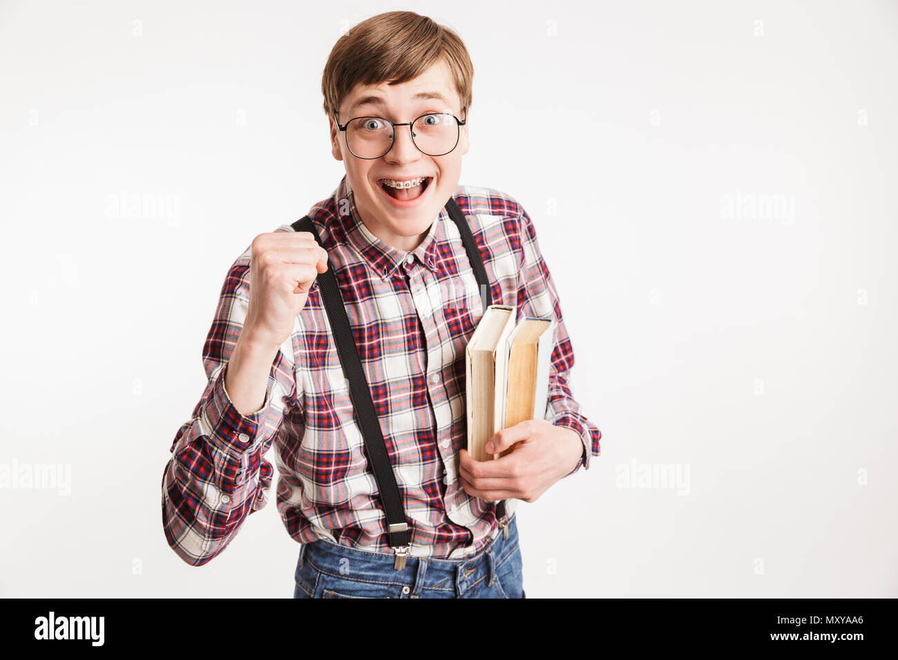 Portrait of an excited young school nerd guy holding book and ...