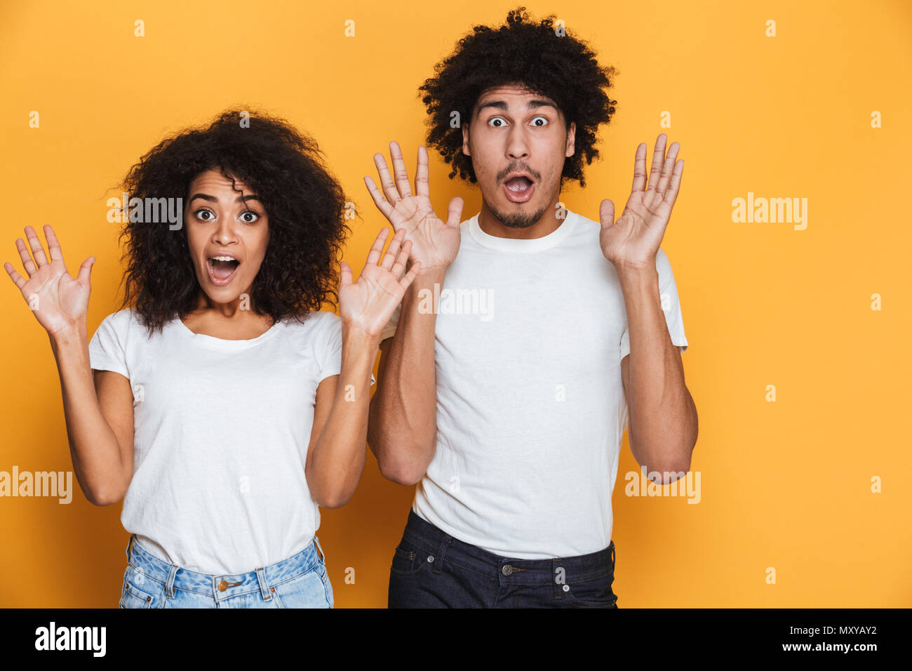 Portrait of a shocked young afro american couple screaming isolated ...
