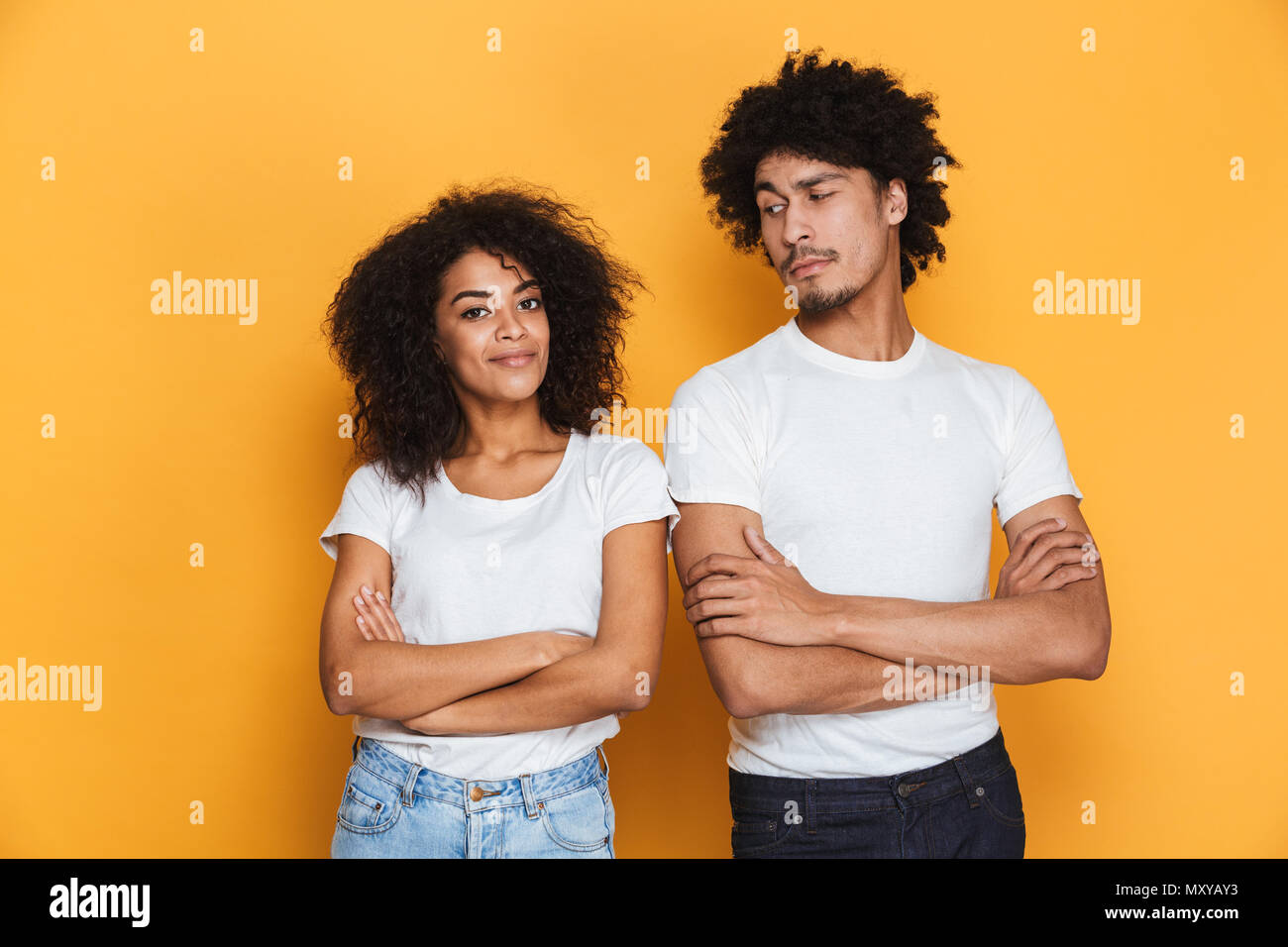 Portrait of a smiling young afro american couple standing with arms ...