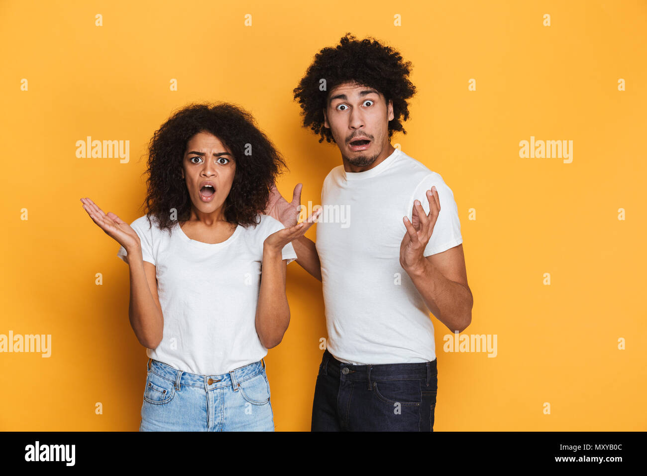 Portrait of a surprised young afro american couple screaming isolated ...
