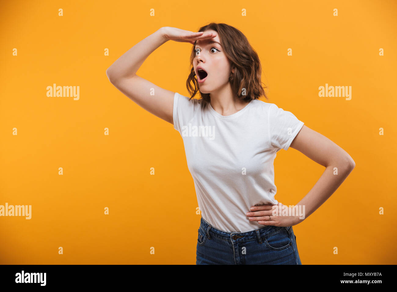 Image of emotional young woman standing isolated over yellow background ...