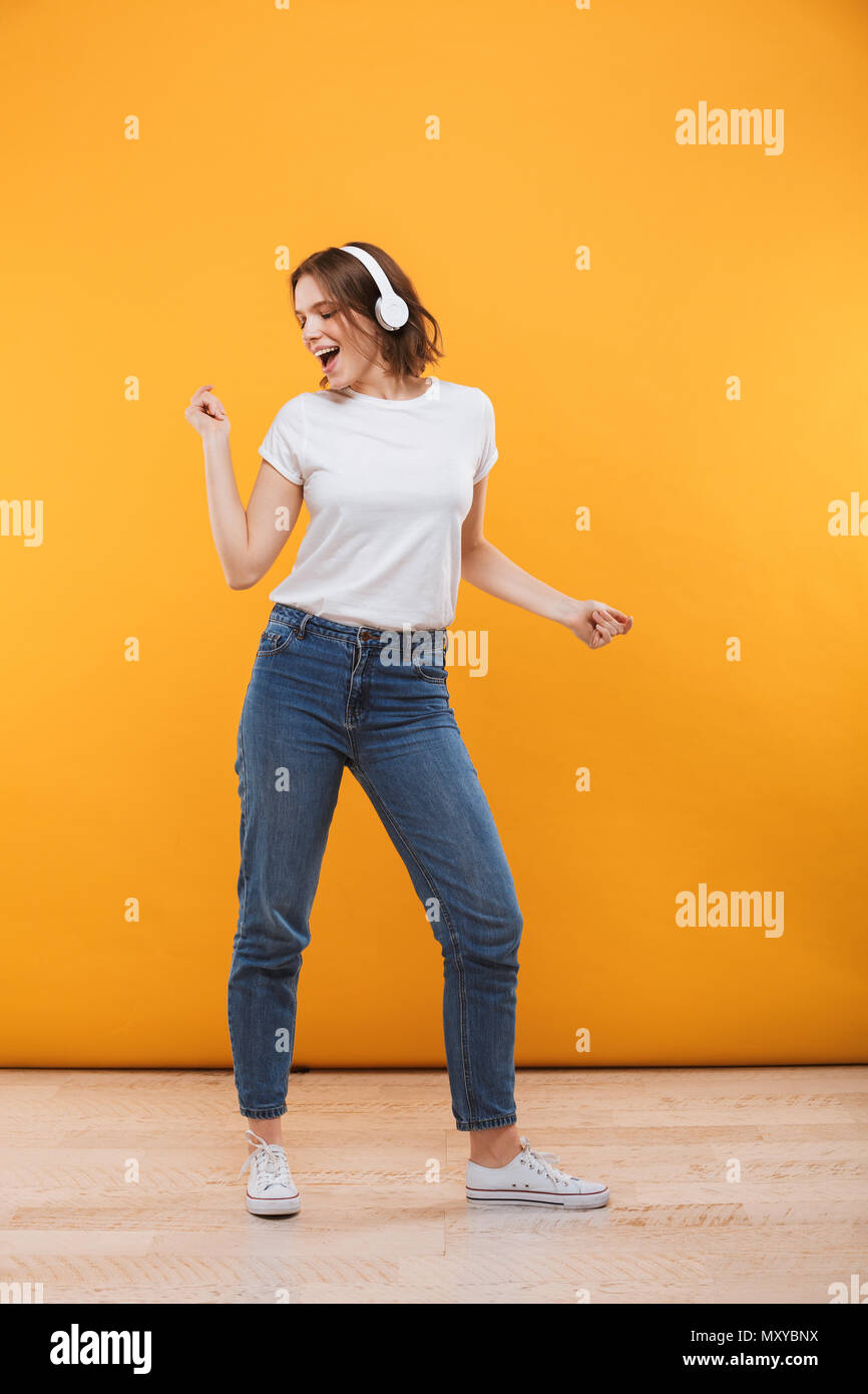 Image of emotional funny young woman standing isolated over yellow ...