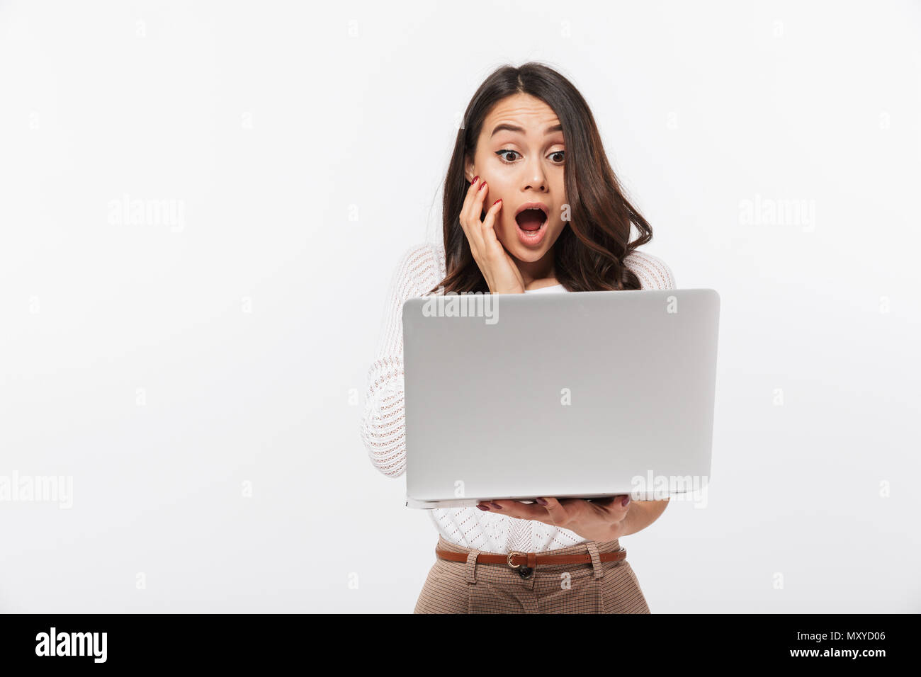 Portrait of a shocked asian businesswoman looking at laptop computer ...