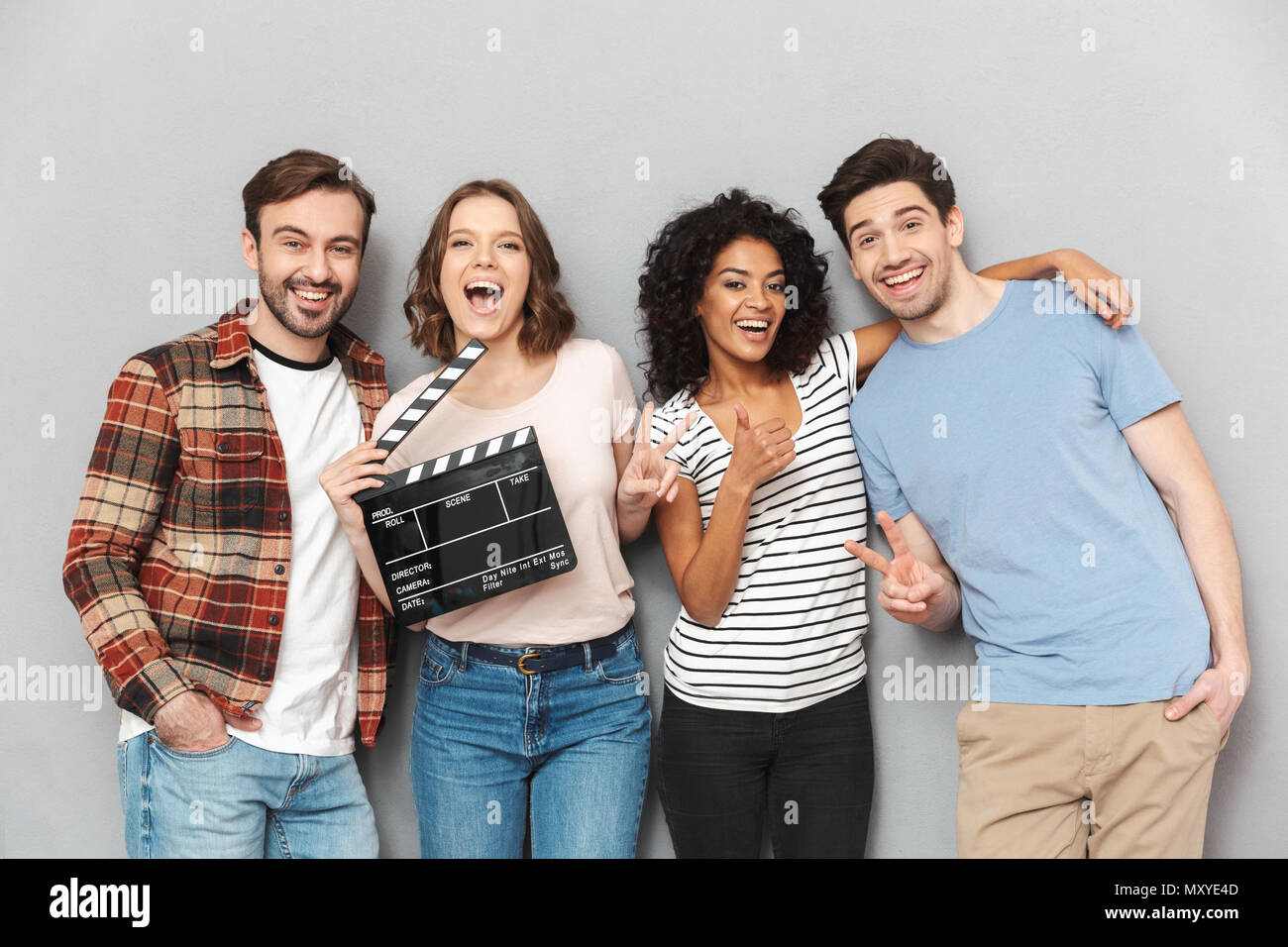 Photo of excited group of friends isolated over grey wall background ...