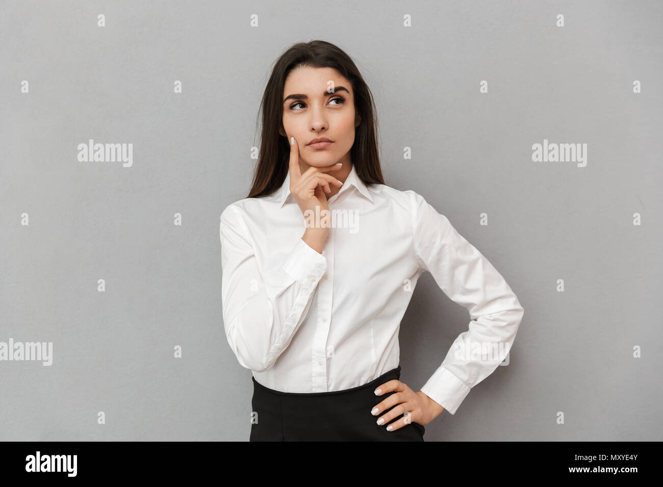 Portrait of young office woman with brooding look in white shirt ...