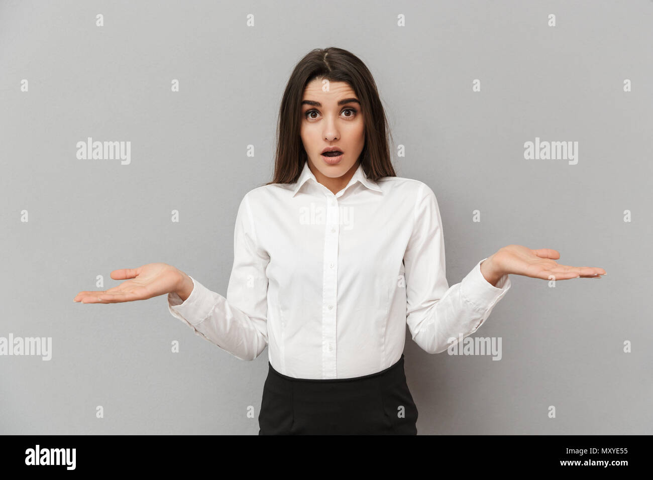 Portrait of perplexed woman in formal dress throwing up hands and ...