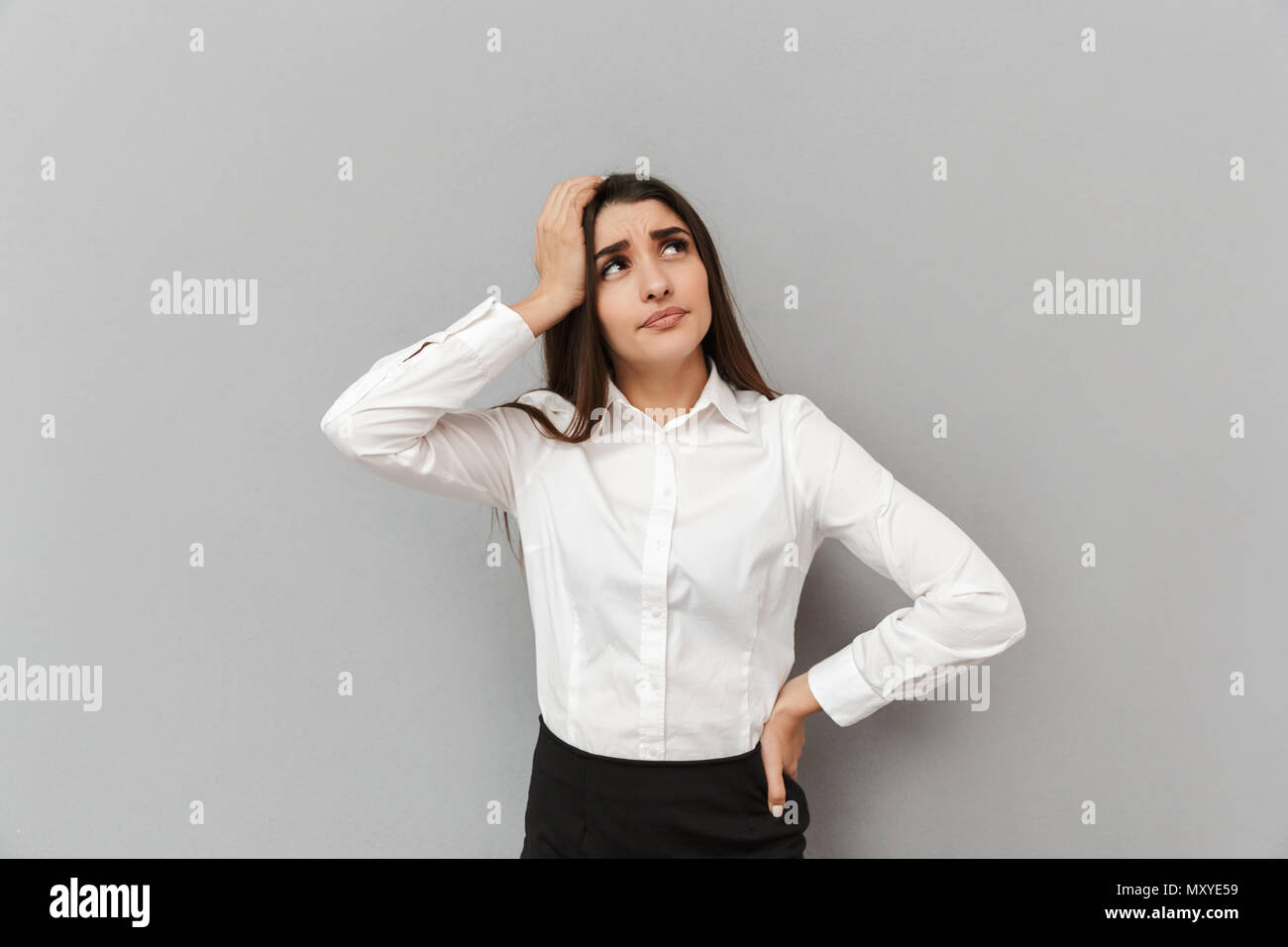 Portrait of young thoughtful office woman with brooding look in white ...