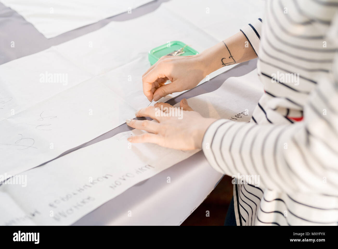 Close up of unrecognizable female tailor tracing fabric with white ...
