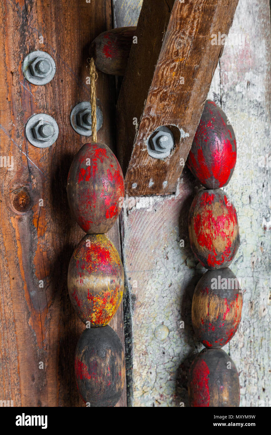 Wooden net floats hanging over a wooden beam in a boatbuilding yard in ...