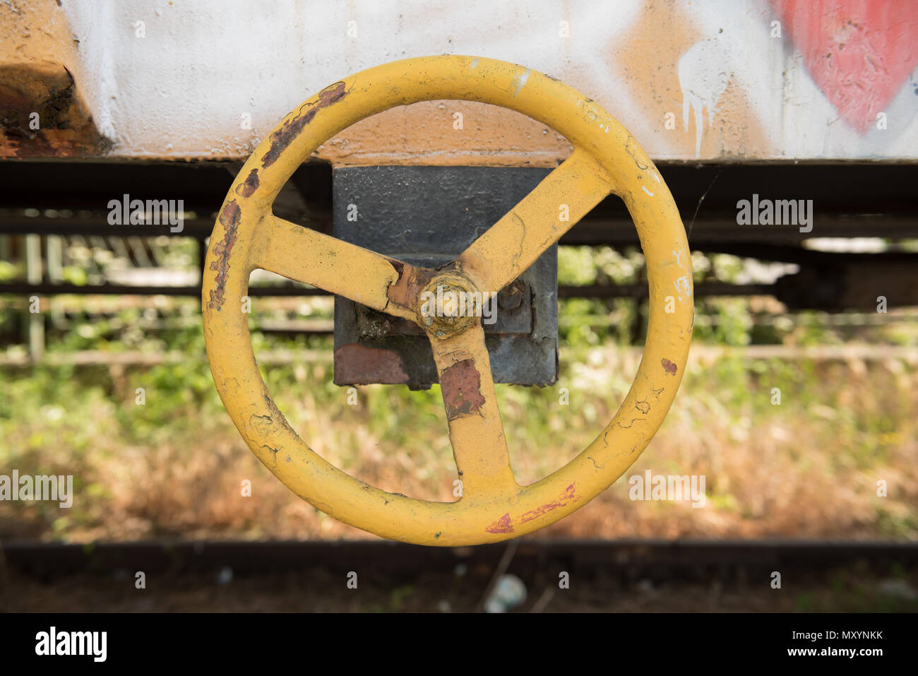 Old yellow and rusty pipe wheel controller Stock Photo - Alamy