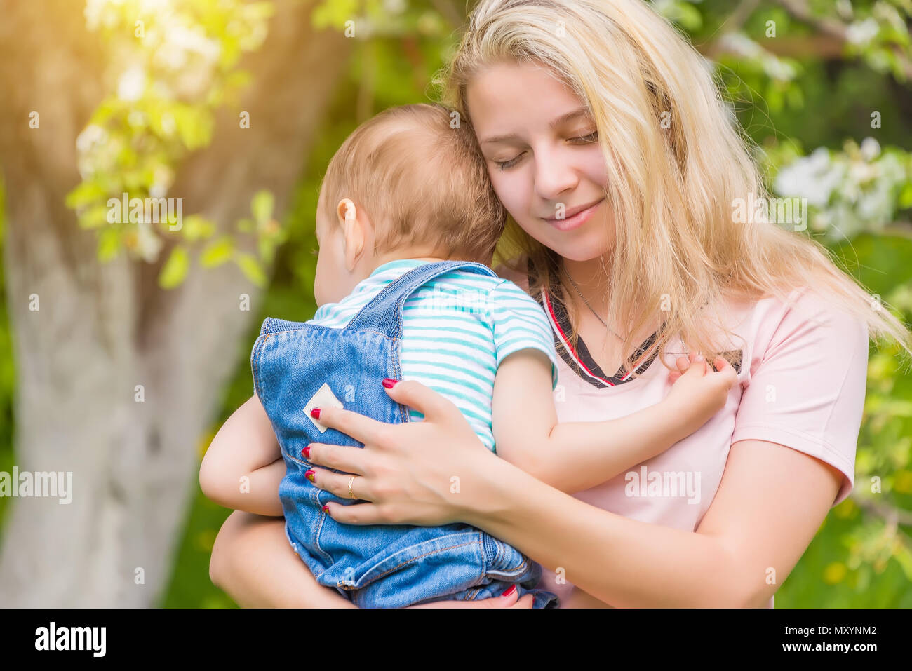 mother and child in nature in the Park, resting on the green grass in ...