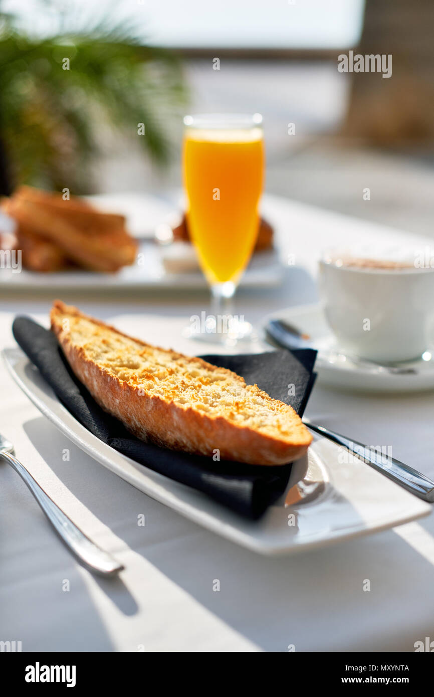 Outdoors restaurant. Table setting with classic breakfast. Orange juice ...