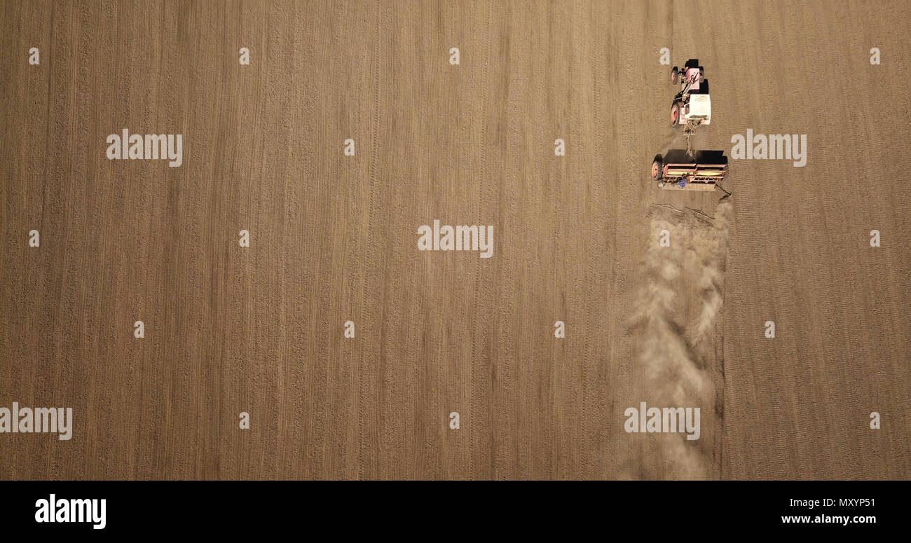 Aerial view of Tractor harvesting field tilling soil Stock Photo - Alamy