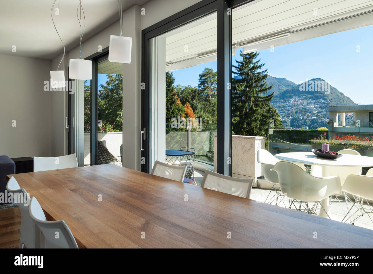 Interior of modern house, dining room with wooden table Stock Photo - Alamy