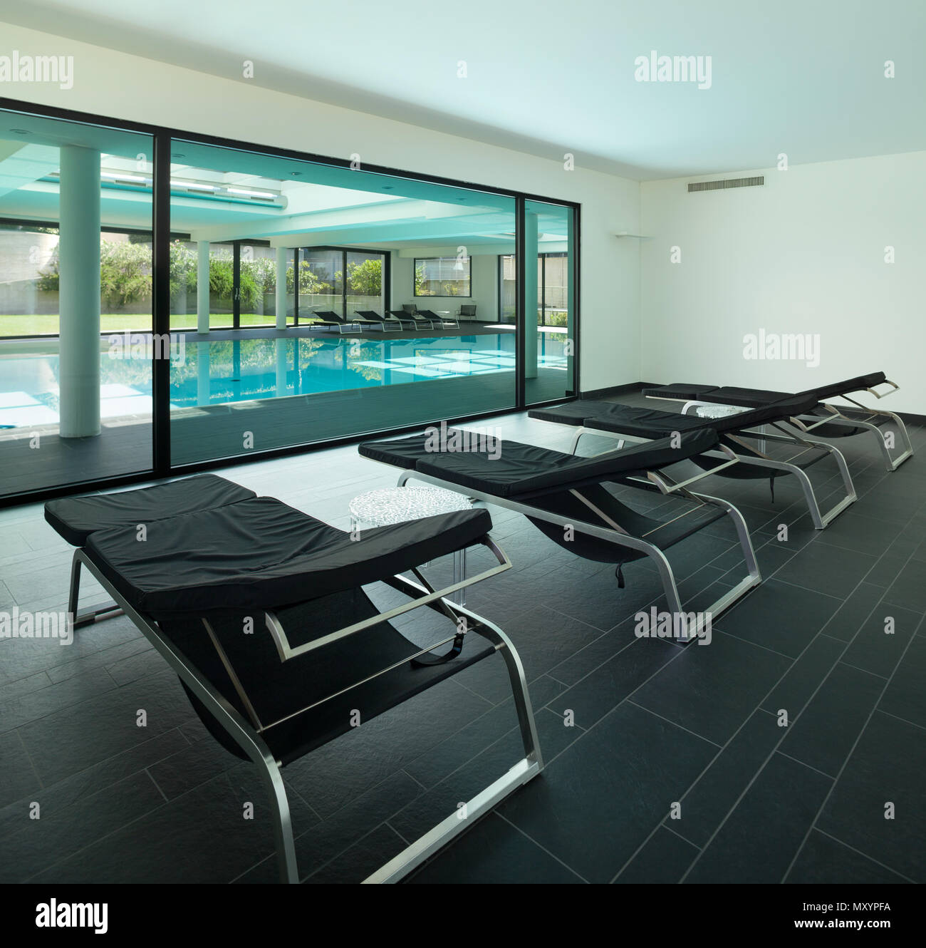 indoor swimming pool of a modern house with spa, room with sunbeds ...