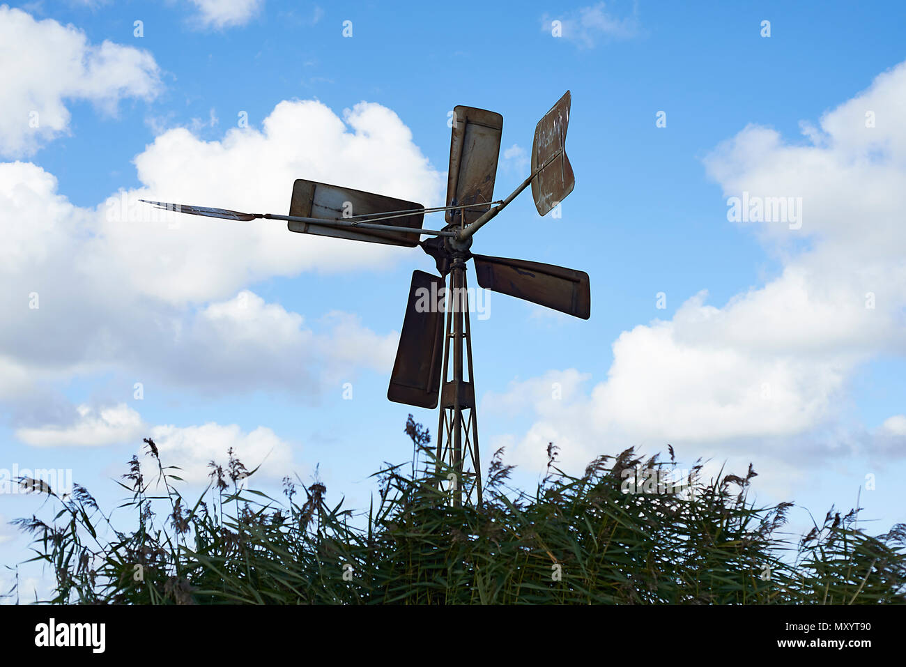 Old metal windmill showing the direction of the wind as its stands in a ...