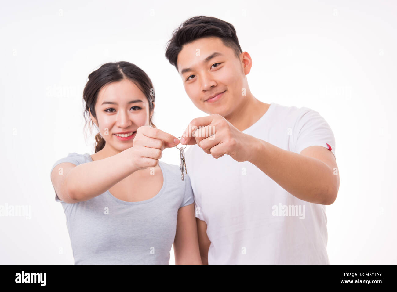 Couple with keys to new home. Happy smiling young couple showing a keys ...