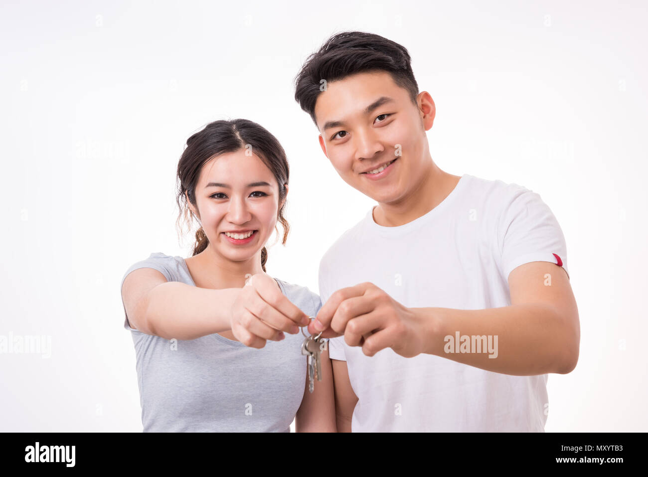Couple with keys to new home. Happy smiling young couple showing a keys ...
