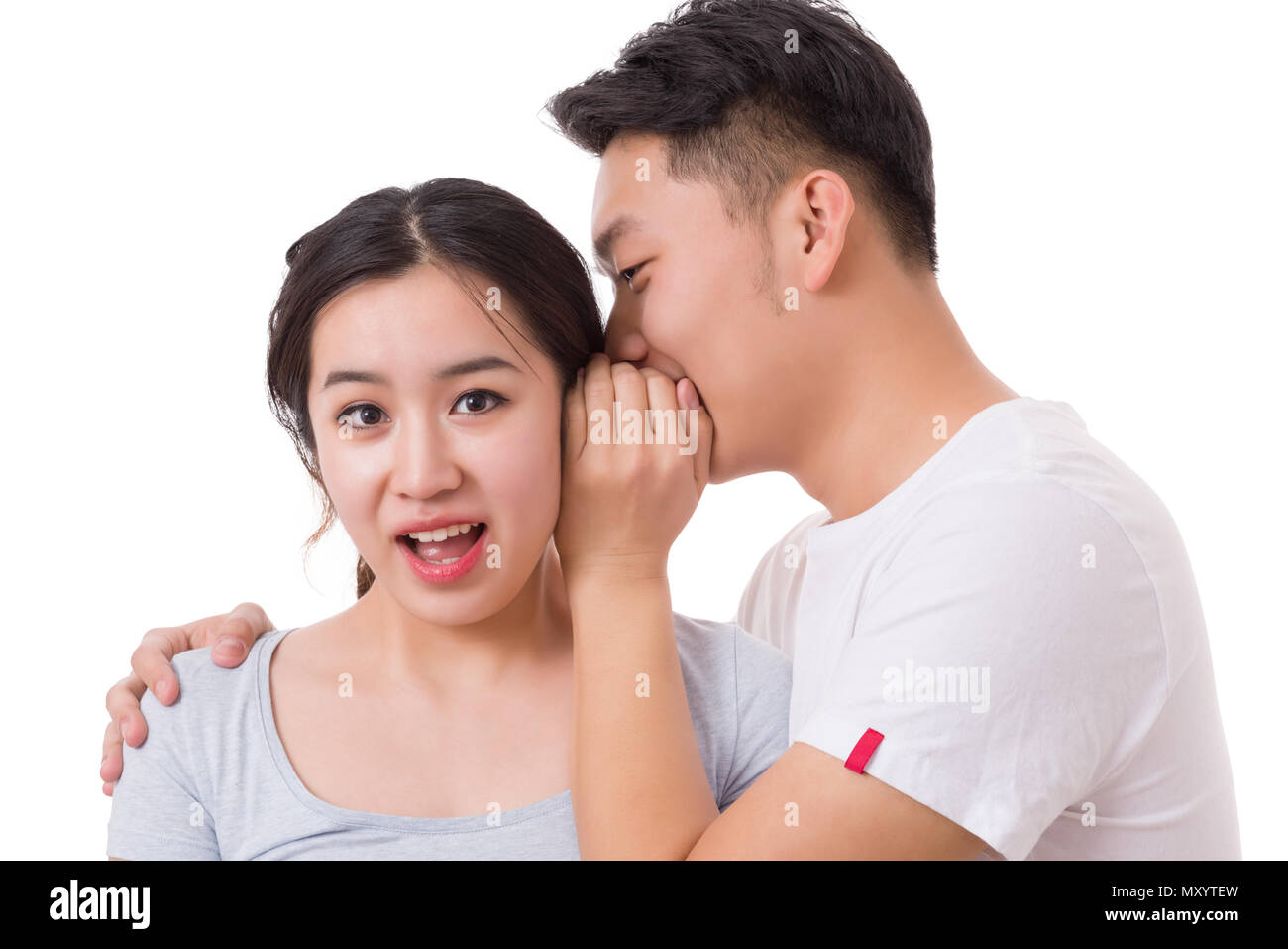 Amazed women is listening gossip in the ear from man, studio shot Stock ...