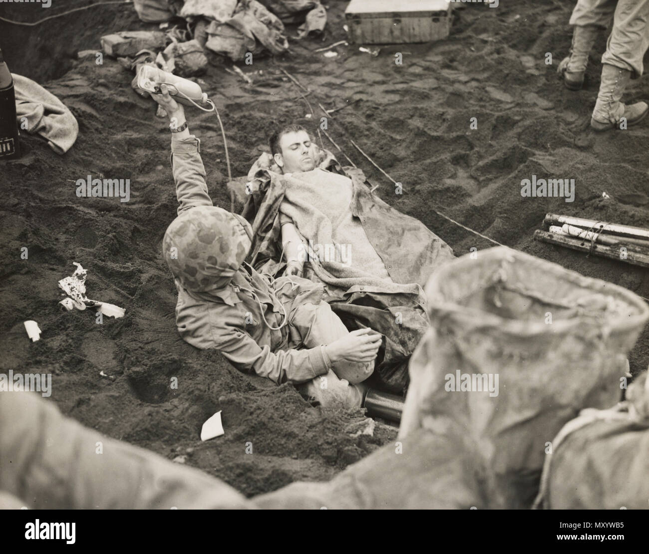 A Navy corpsman adminsiters blood plasma to a wounded soldier on Iwo ...