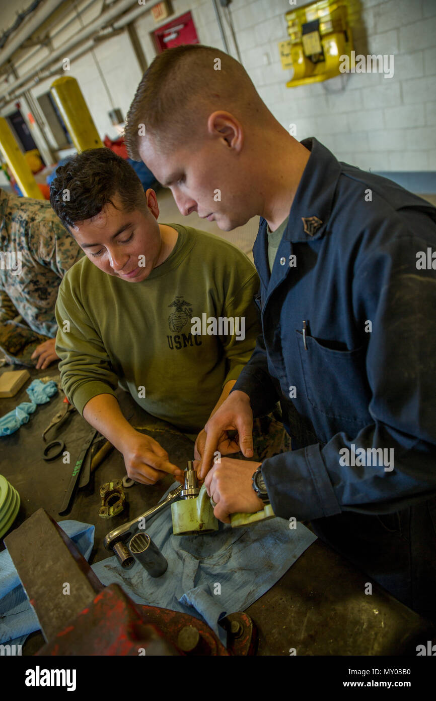 Sergeant Jake Mettam Instructs Another Marine On How To Properly