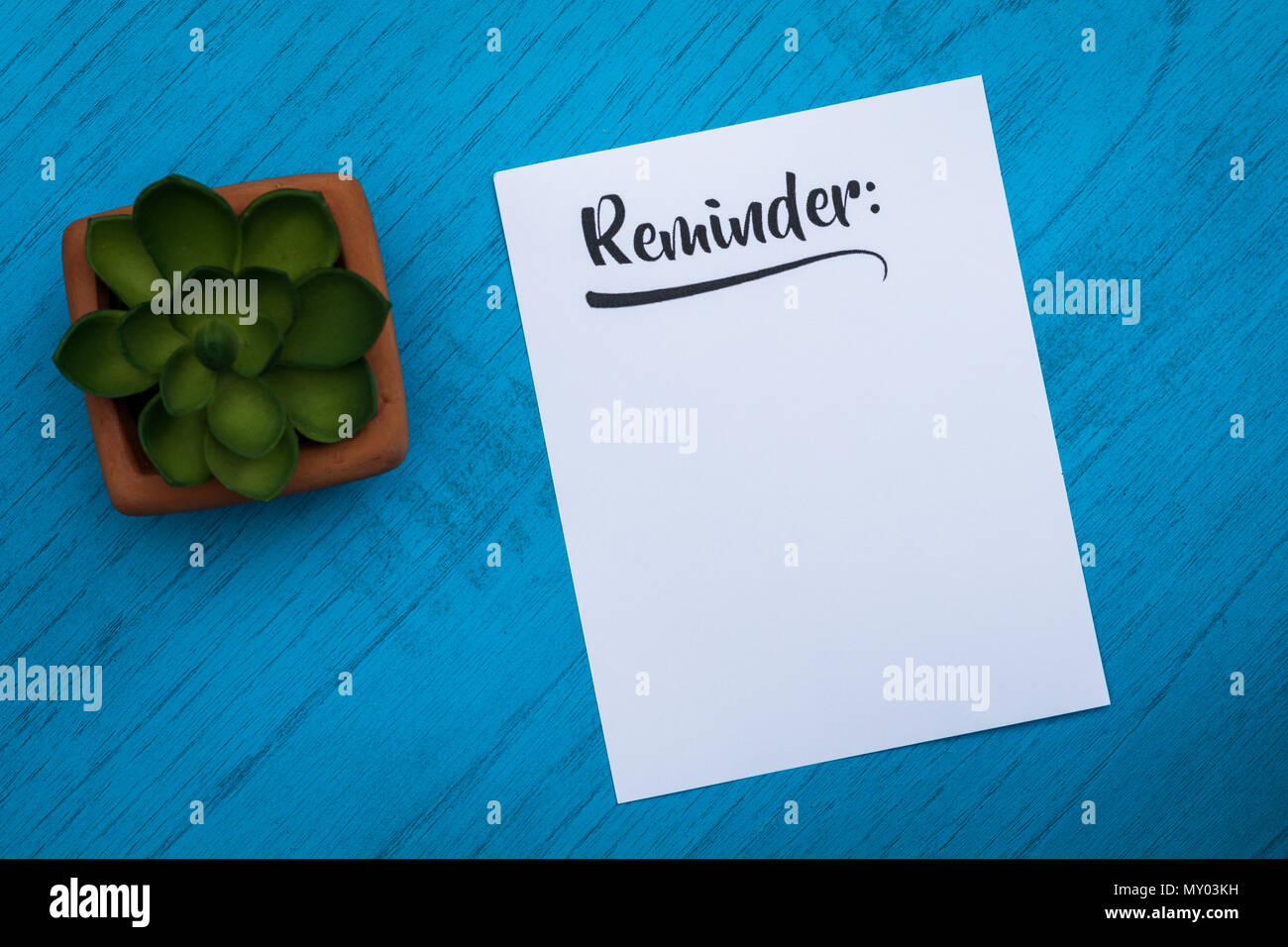 Reminder still life motivational concept on white paper and blue table ...