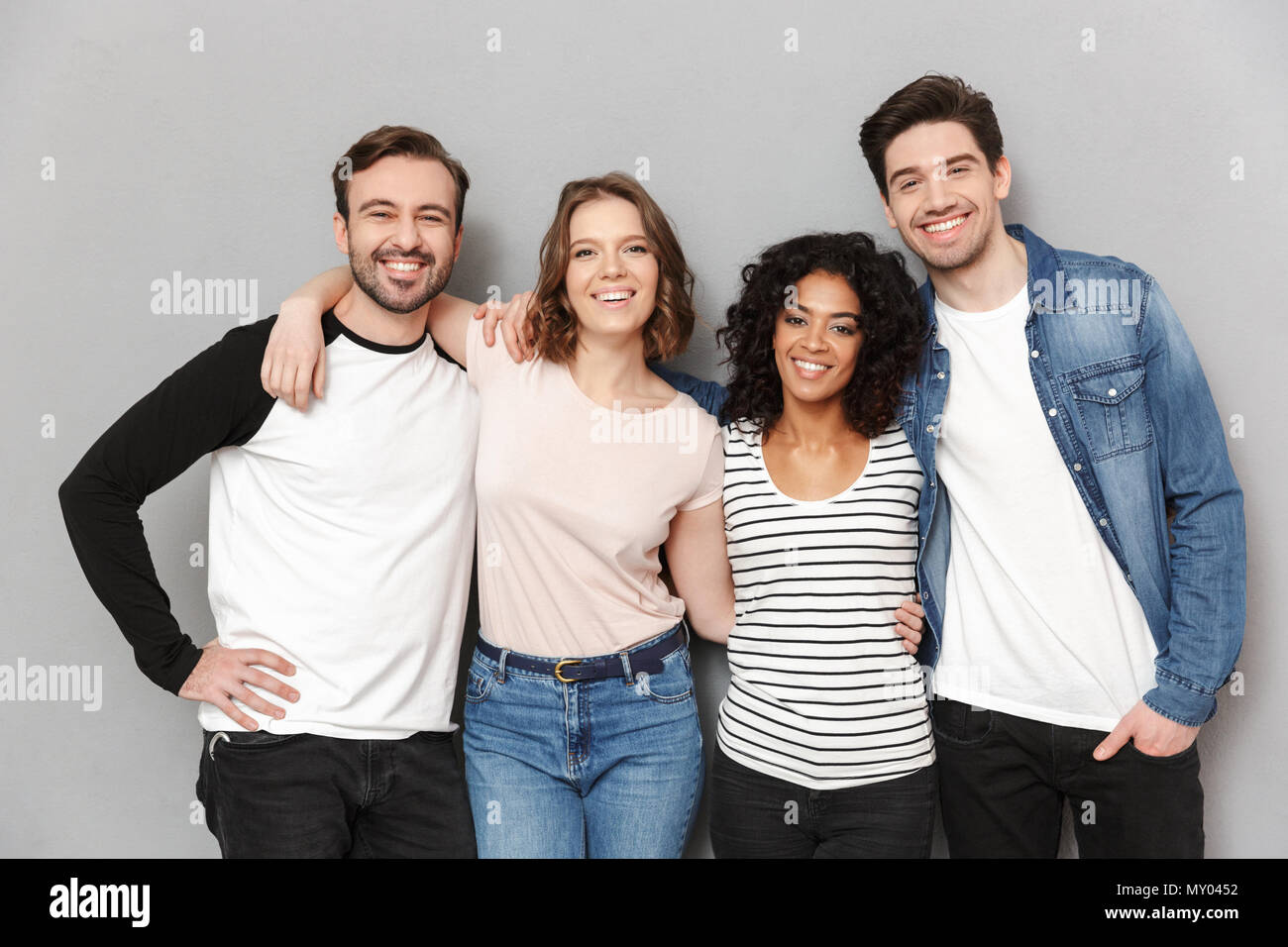 Image of happy group of friends standing isolated over grey wall ...