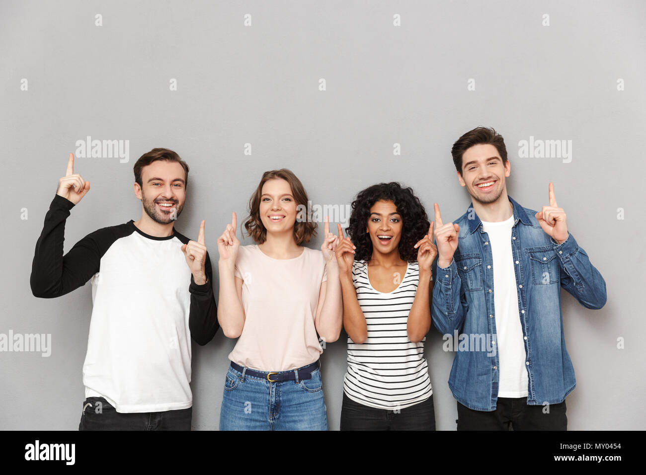 Image of happy group of friends standing isolated over grey wall ...
