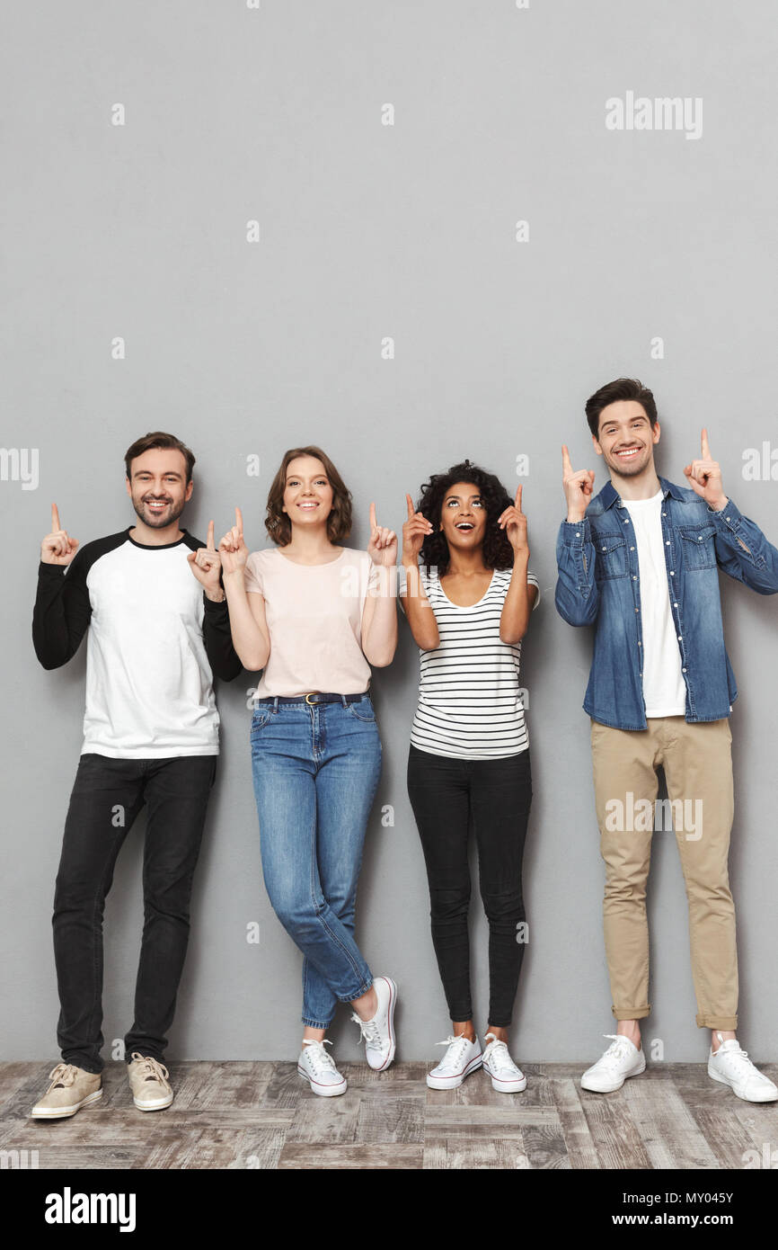 Image of emotional excited group of friends standing isolated over grey ...