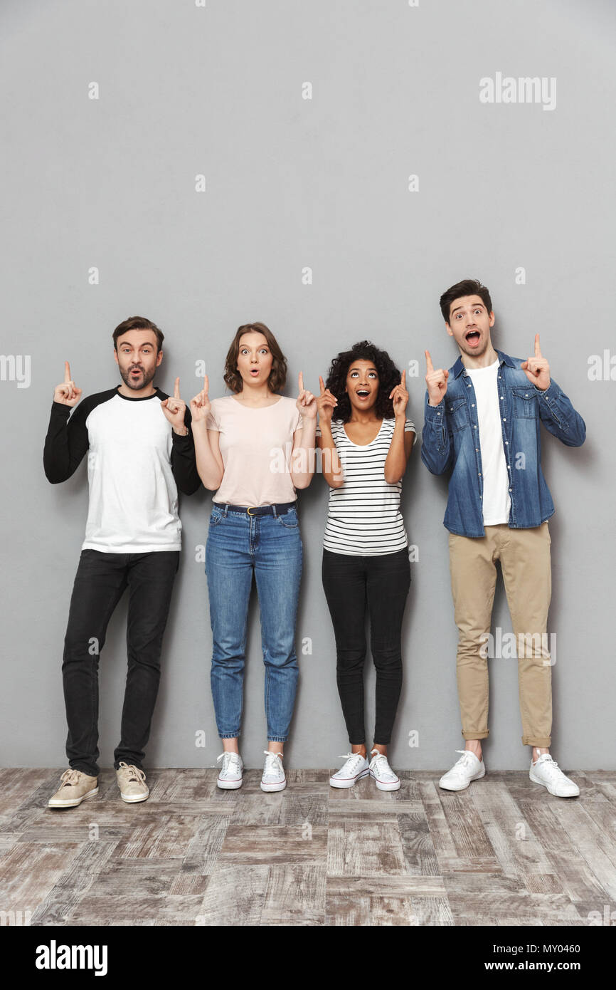 Photo of shocked excited group of friends standing isolated over grey ...