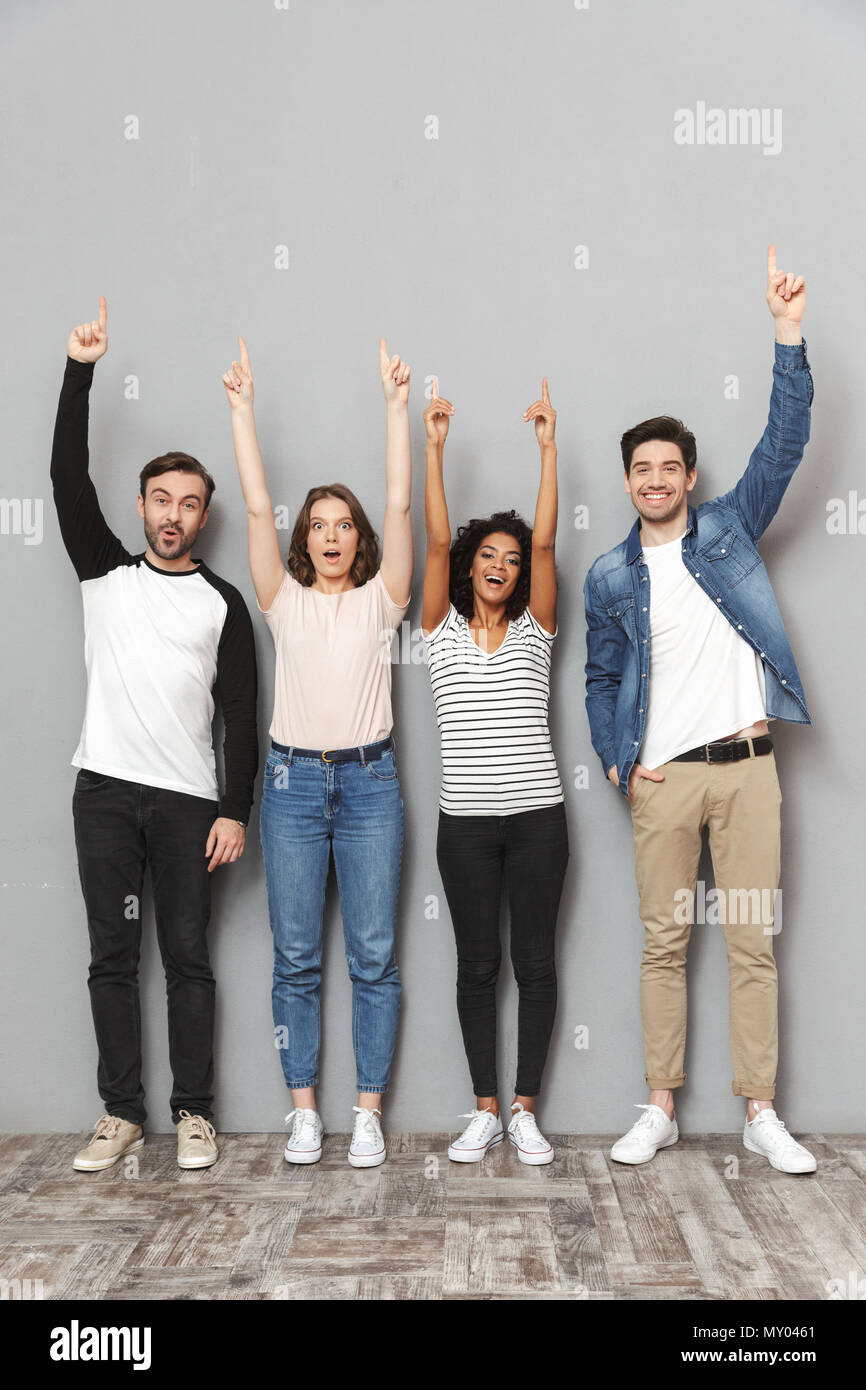 Image of emotional excited group of friends standing isolated over grey ...