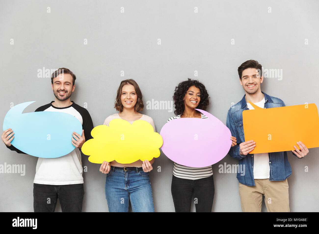 Image of emotional group of friends standing isolated over grey wall ...