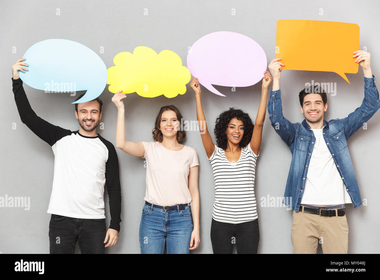 Image of emotional group of friends standing isolated over grey wall ...