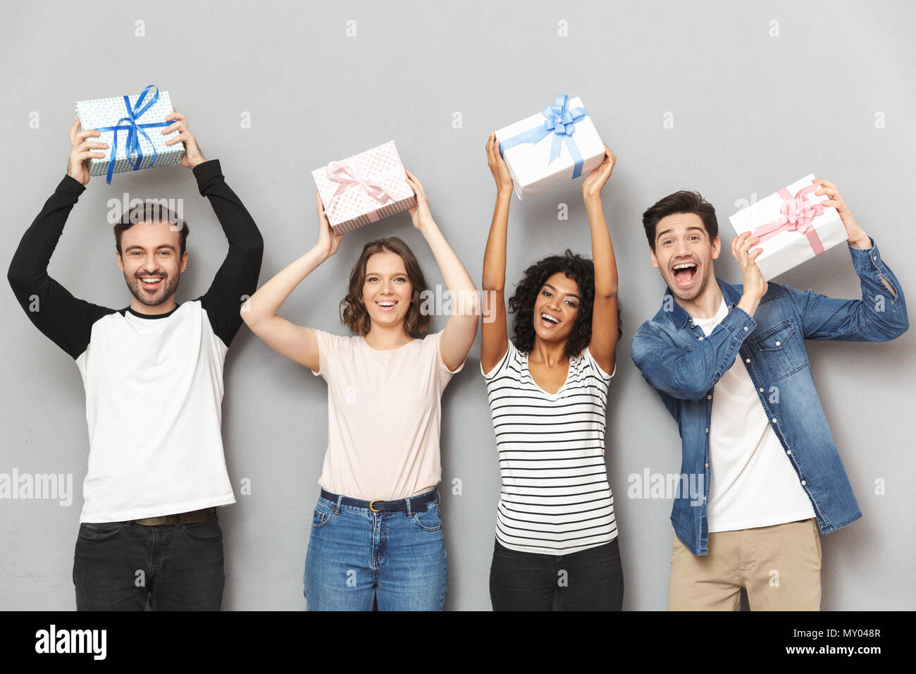 Image of excited group of friends standing isolated over grey wall ...