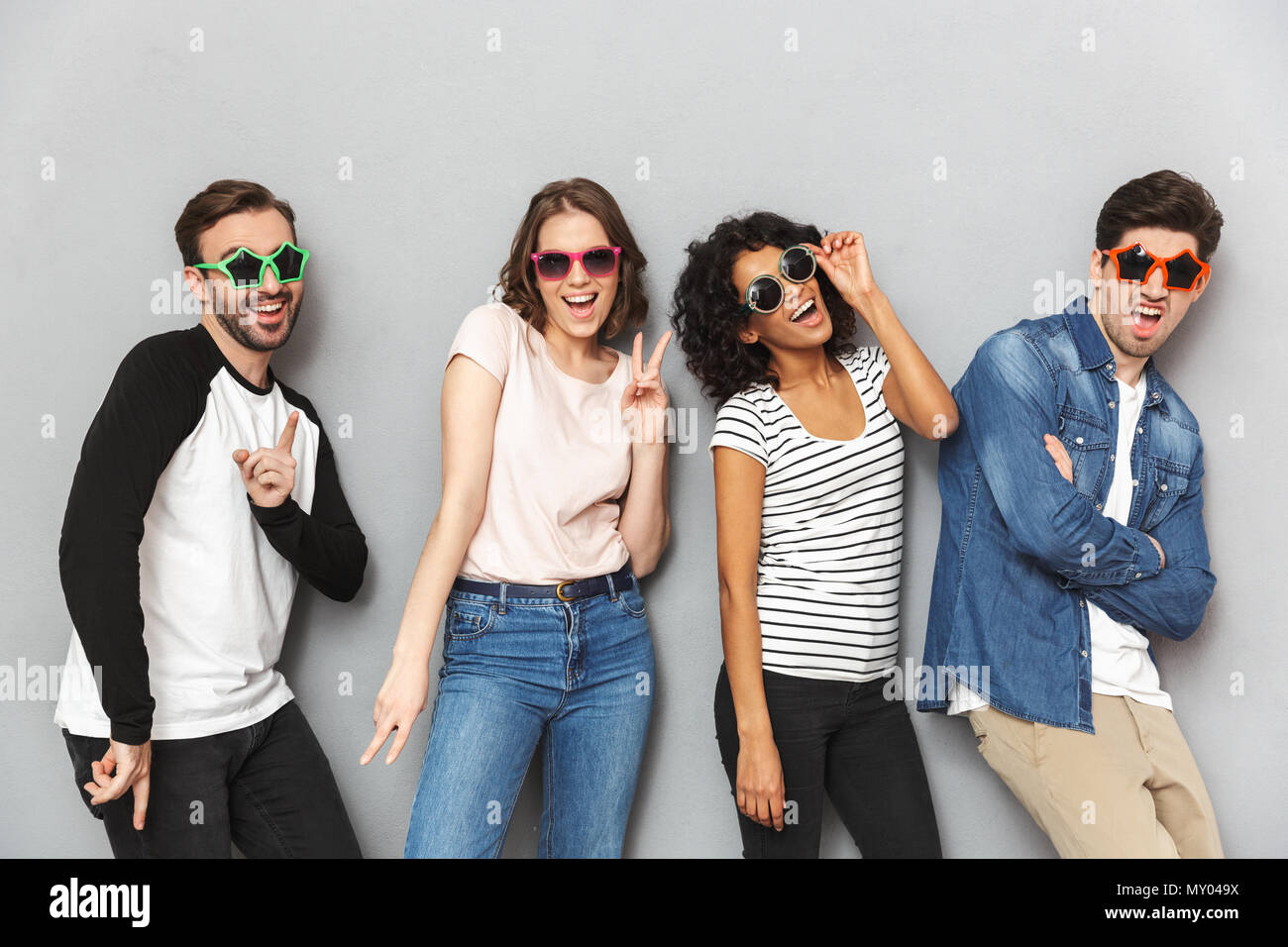 Image of happy group of friends standing isolated over grey wall ...
