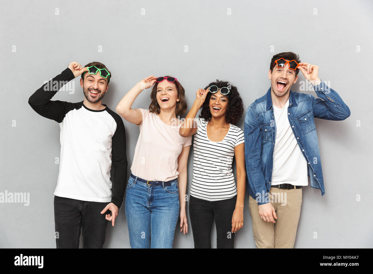 Image of happy group of friends standing isolated over grey wall ...