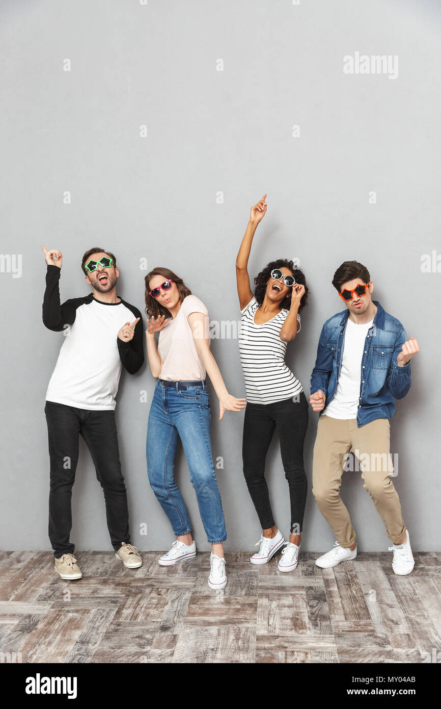 Image of happy group of friends standing isolated over grey wall ...