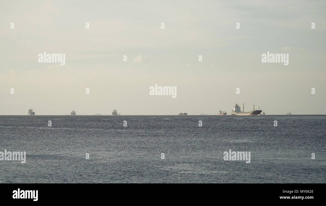 Cargo ships in the Bay of Manila. Large container ship in the sea, blue ...