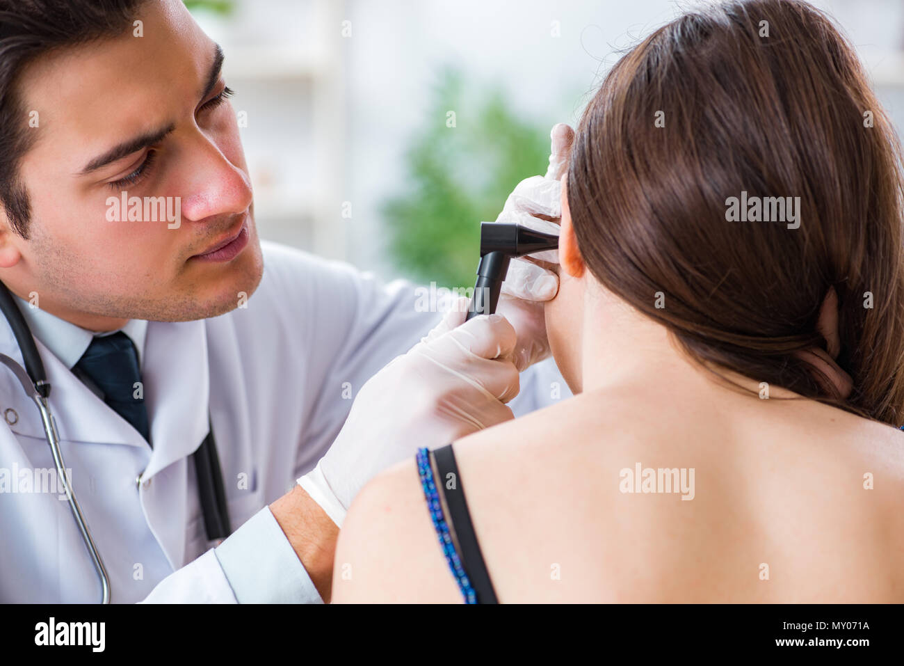 Doctor checking patients ear during medical examination Stock Photo - Alamy