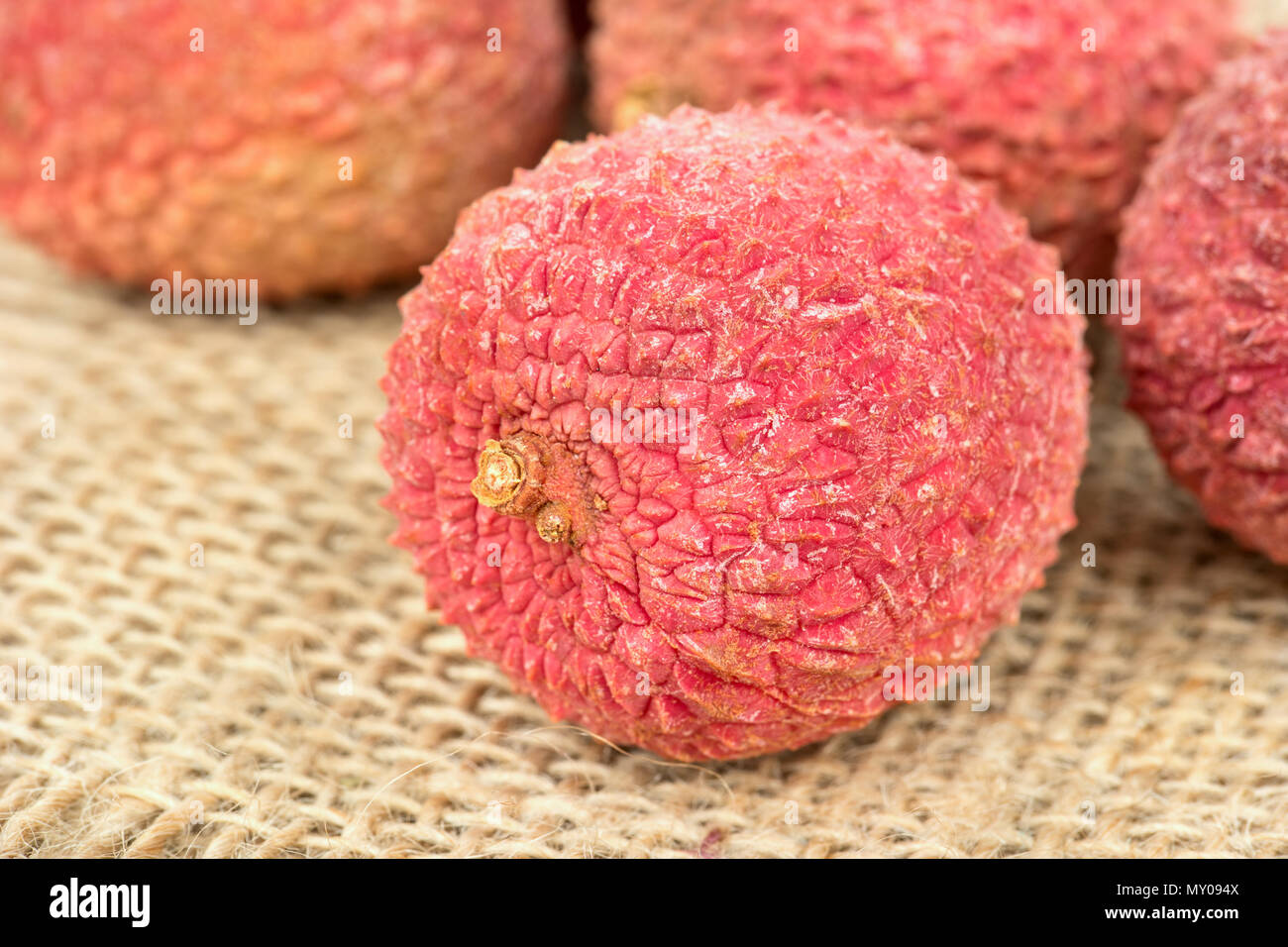 Scattered fruit lychee in the shell on sackcloth close up Stock Photo ...